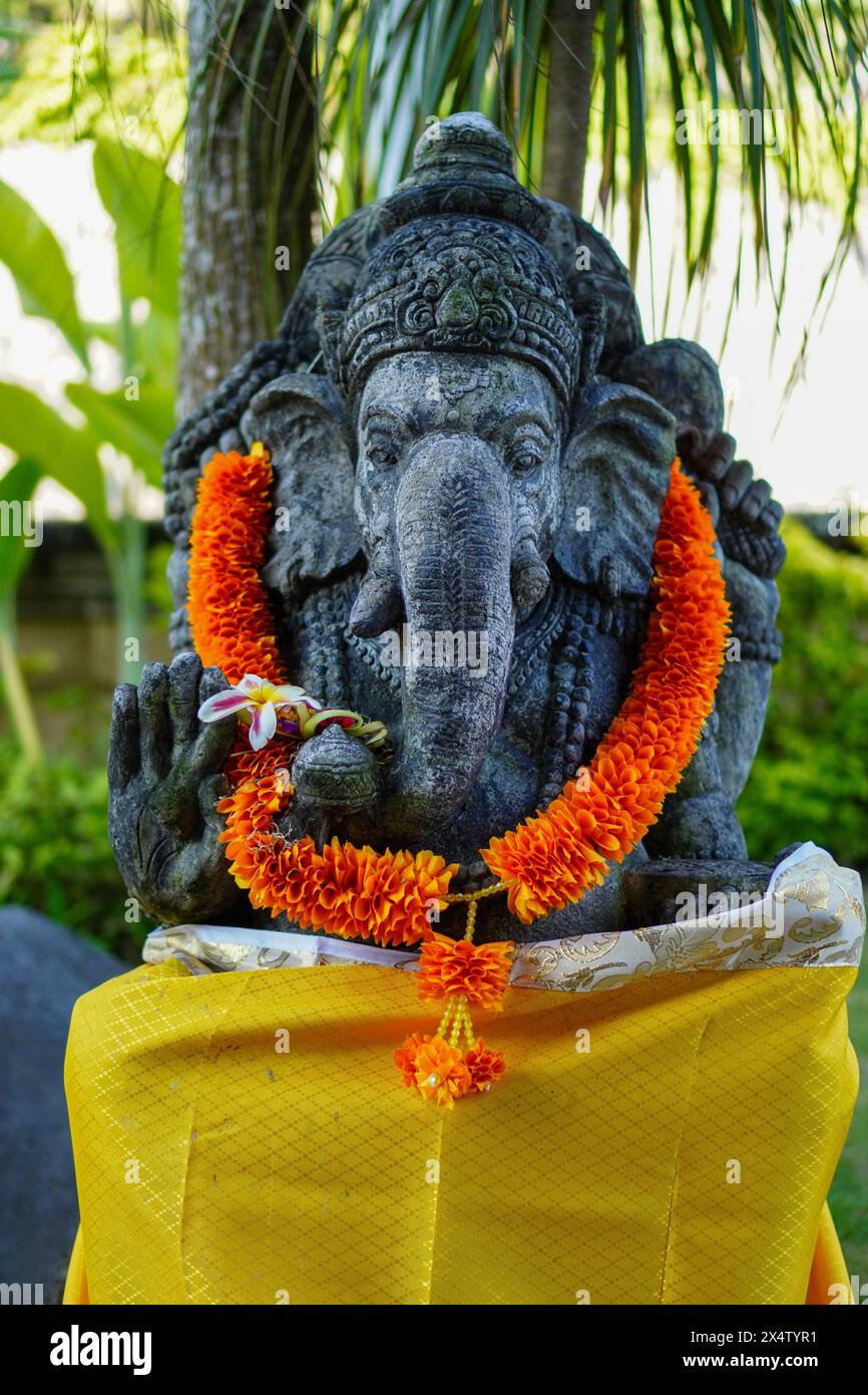 Statue of Lord Ganesha with a yellow garland, a tradition of Hindu Bali ...