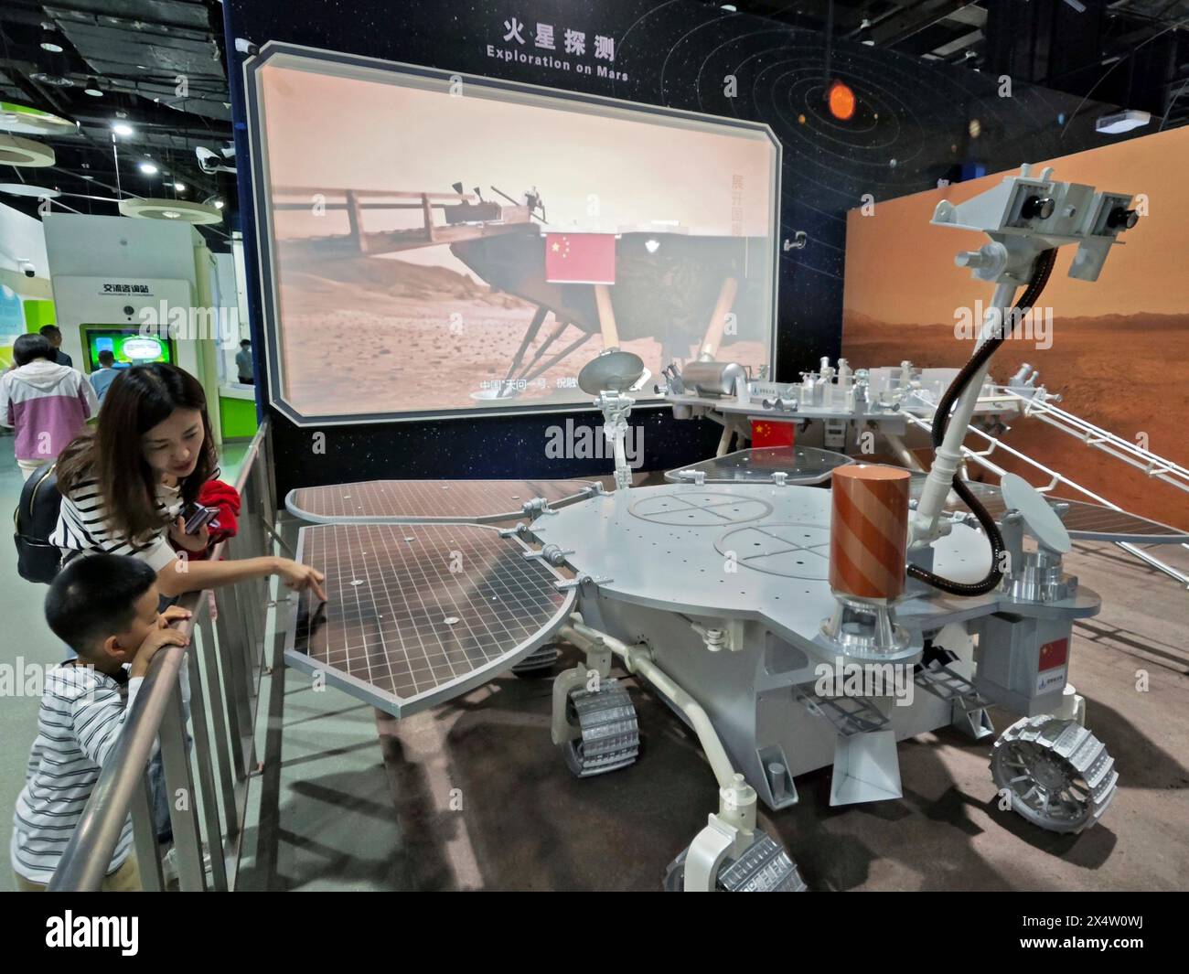 A mother talks to her child about the model of Zhurong Mars Rover at ...
