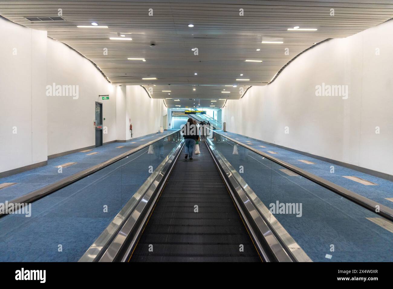Passengers walking in travelator at airport Stock Photo - Alamy