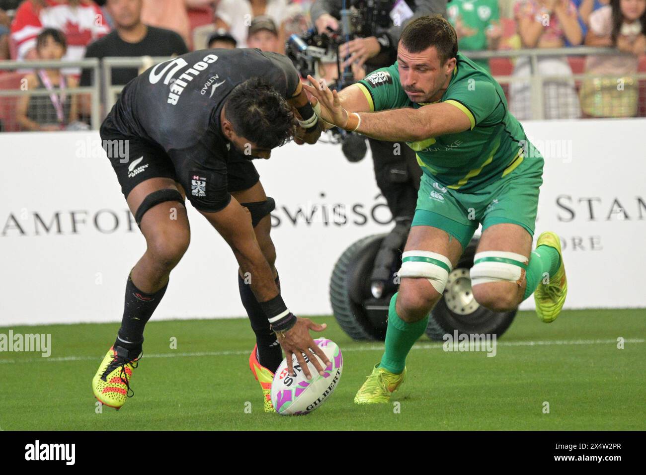 Singapore. 5th May, 2024. New Zealand's Dylan Collier (L) scores a try ...