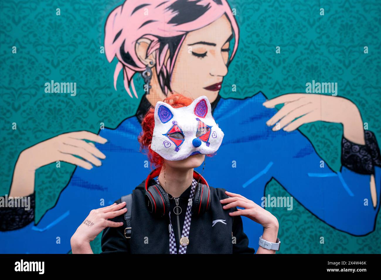 Visitor Hachi Kotula alongside a mural by artist Lightbody107 at the Yardworks Festival 2024 in ...