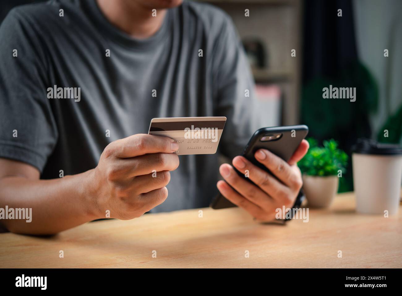 Man verifying credit card details on a smartphone, emphasizing ...