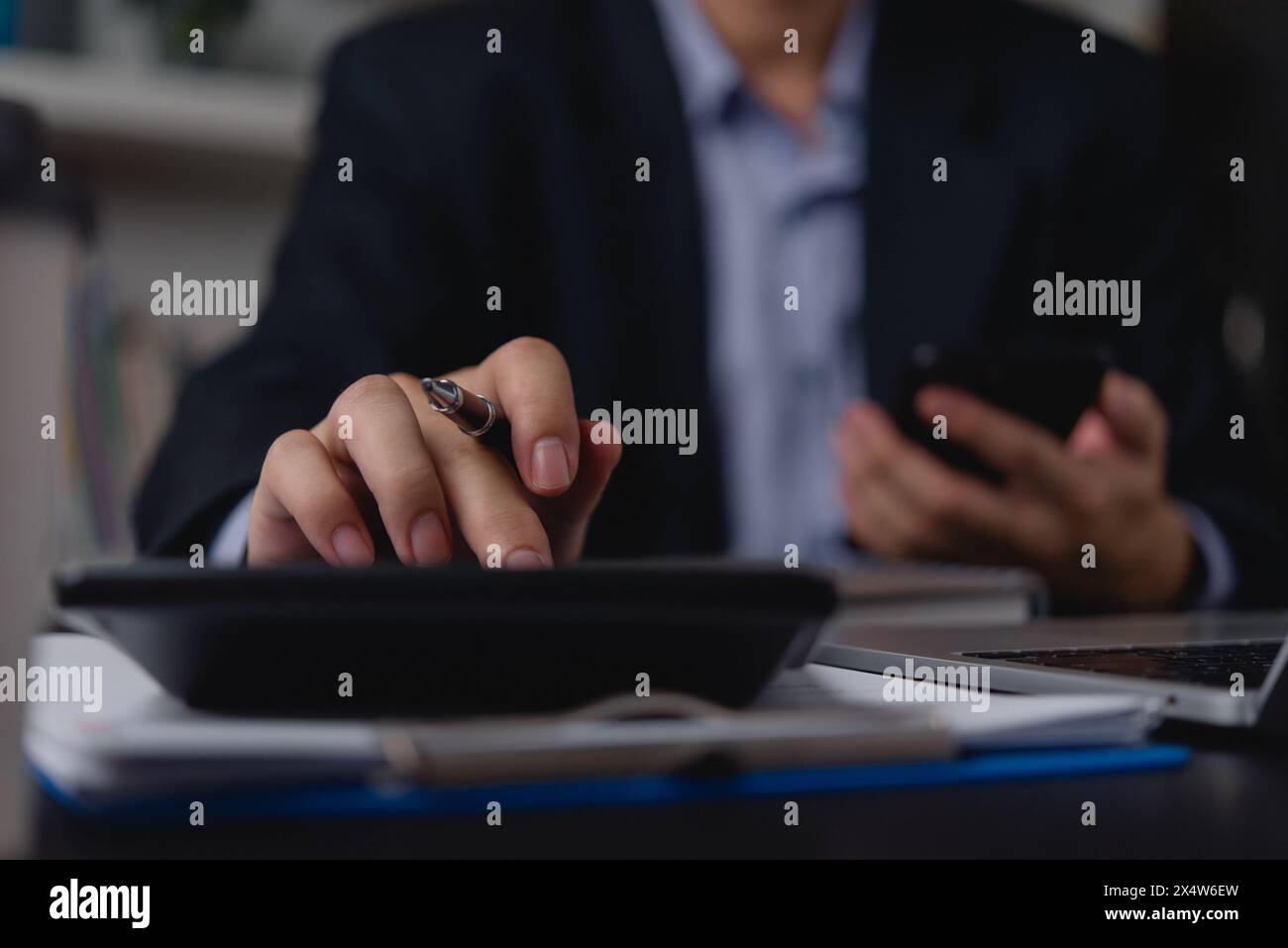 businessman hands using a smartphone and calculator simultaneously ...