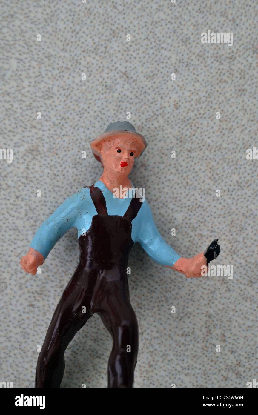 Plastic model of man in overalls holding tool like pincers or wrench ...