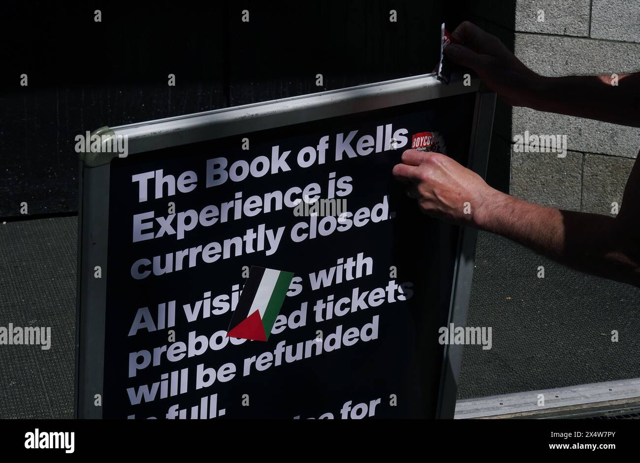 A man removes anti-Israel stickers from a sign at an entrance to ...