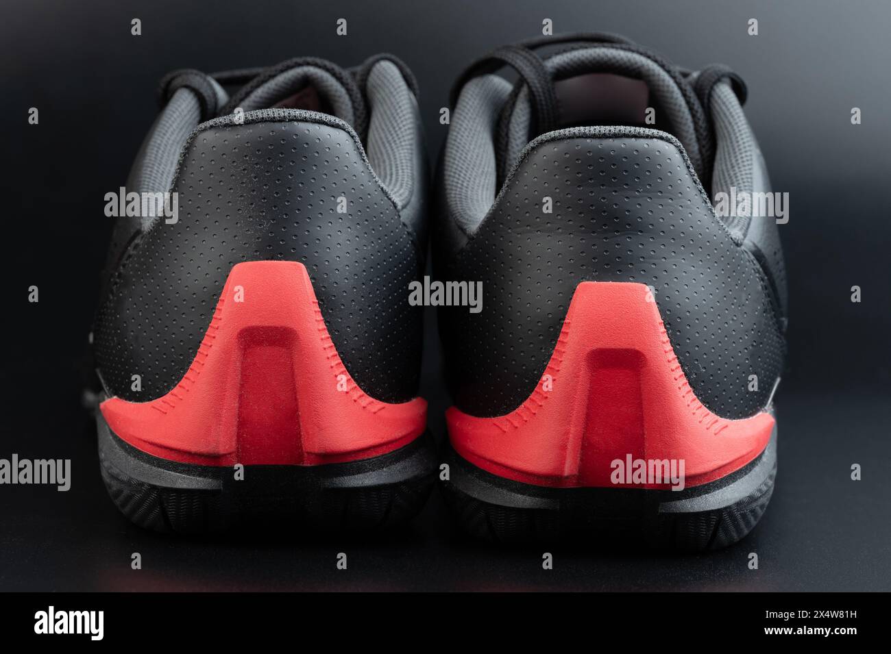 Rear view of pair black leather shoes with red sole isolated on studio ...