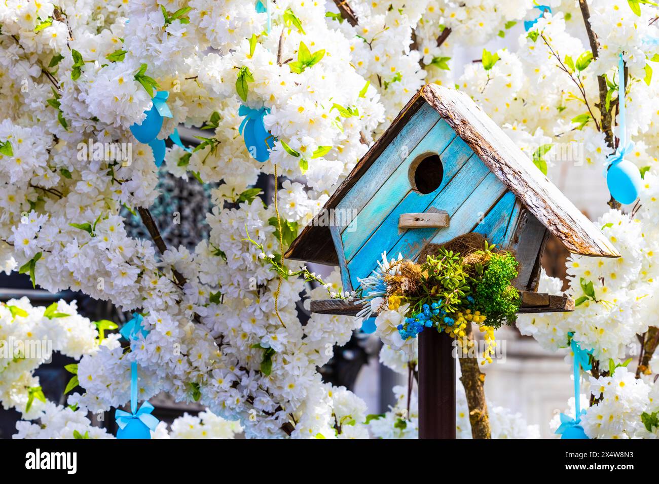 wooden birdhouse on the Easter tree, close-up. tree with easter eggs. outdoor easter decoration ...