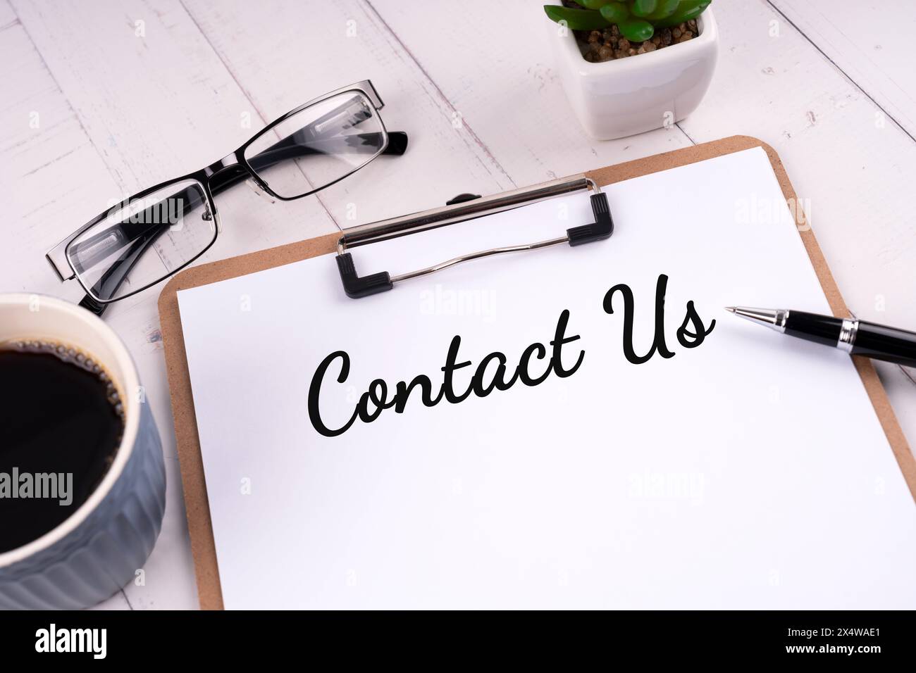 Contact us text on clipboard business concept Stock Photo - Alamy