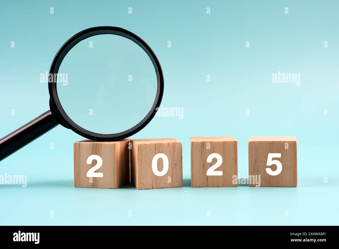 Magnifying glass and 2025 number engraved on wood block New Year ...