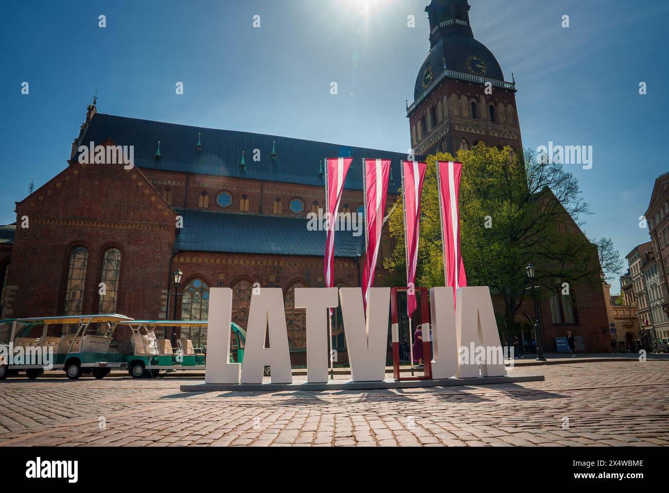Sunny day in Riga, Latvia with LATVIA letters in front, flag colors ...
