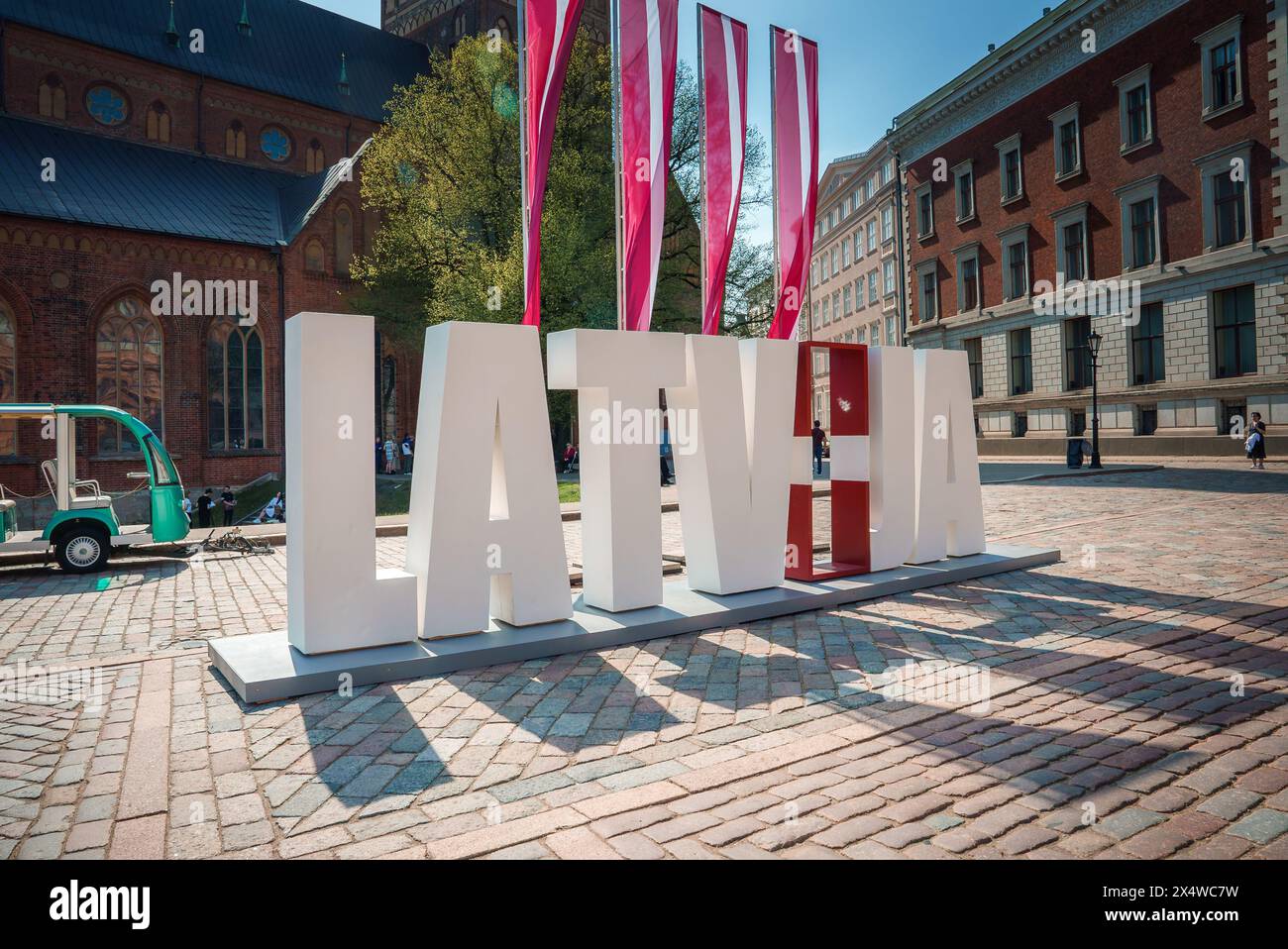 Sunny day in Riga, Latvia with LATVIA letters in front, flag colors ...