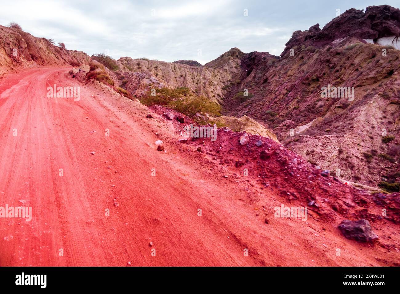 The red road through the island of Hormuz of volcanic origin. Terra ...
