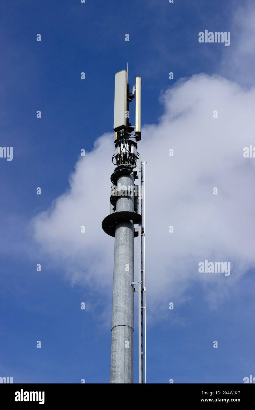 Roadside communications mast with telecoms installations against blue ...