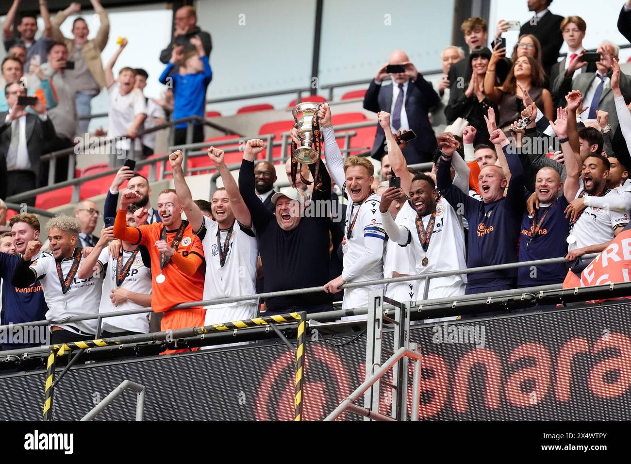 Bromley manager Andy Woodman (centre) and captain Byron Webster lift ...