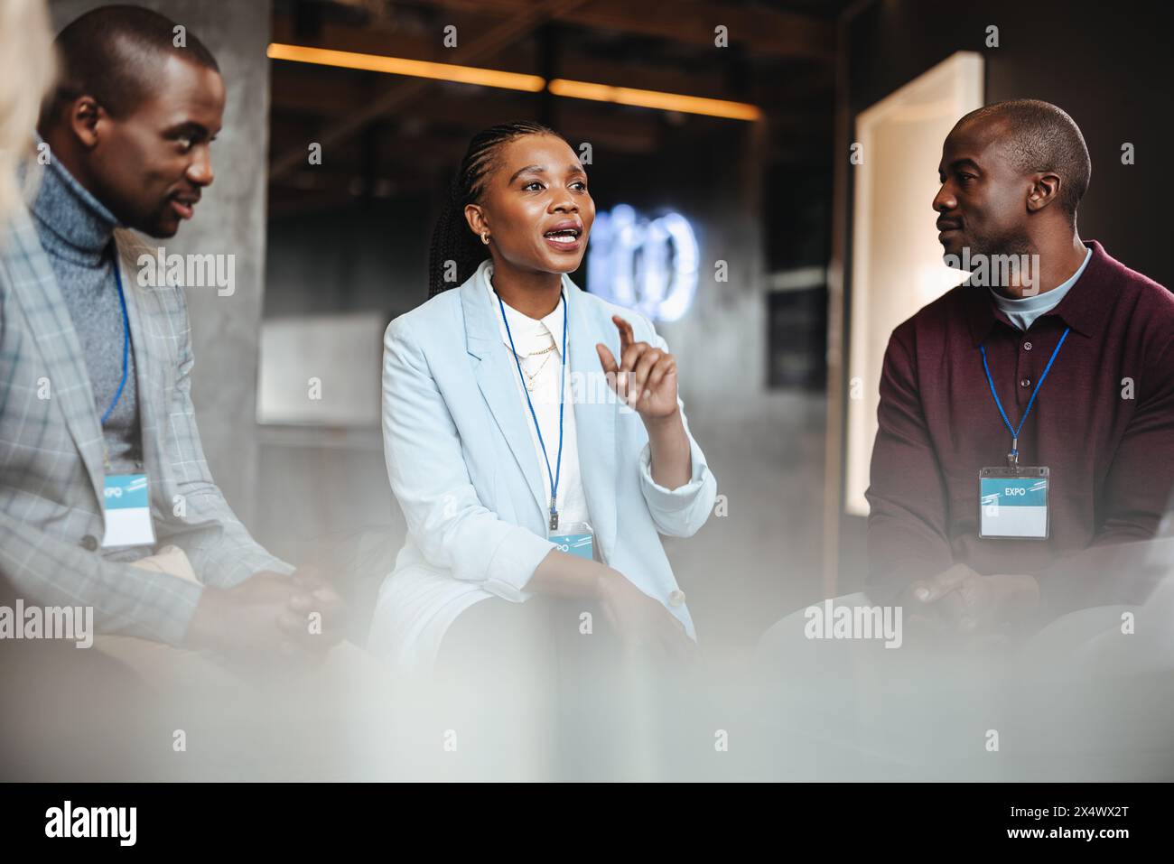 Three business professionals engage in a focused discussion at a ...