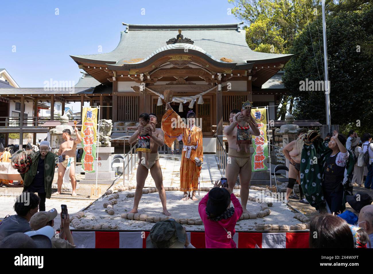 Crying babies are being lifted in the air by sumo wrestlers during ...