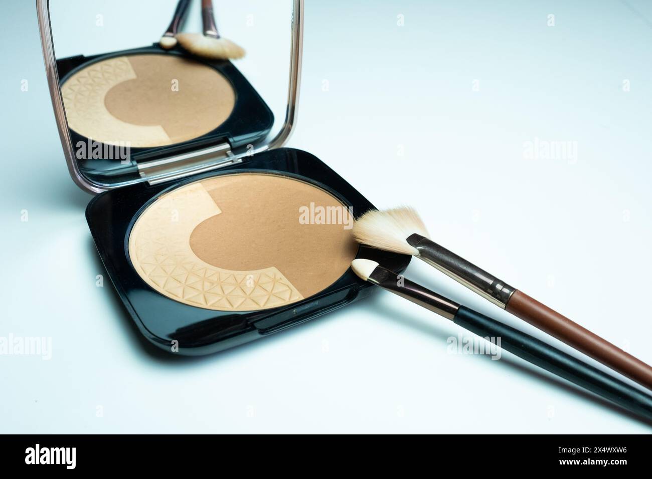 A small makeup kit with a mirror and with bronzing powders and two ...