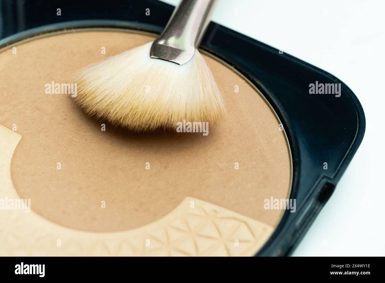 A small makeup kit with bronzing powders and a brush to apply them on ...