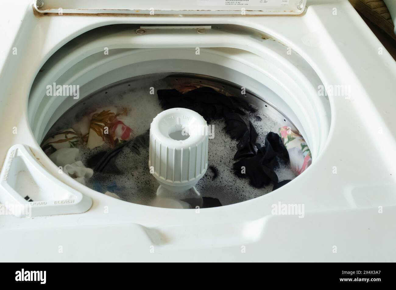 Clothes in Washing Machine Filled with Soapy Water Stock Photo - Alamy