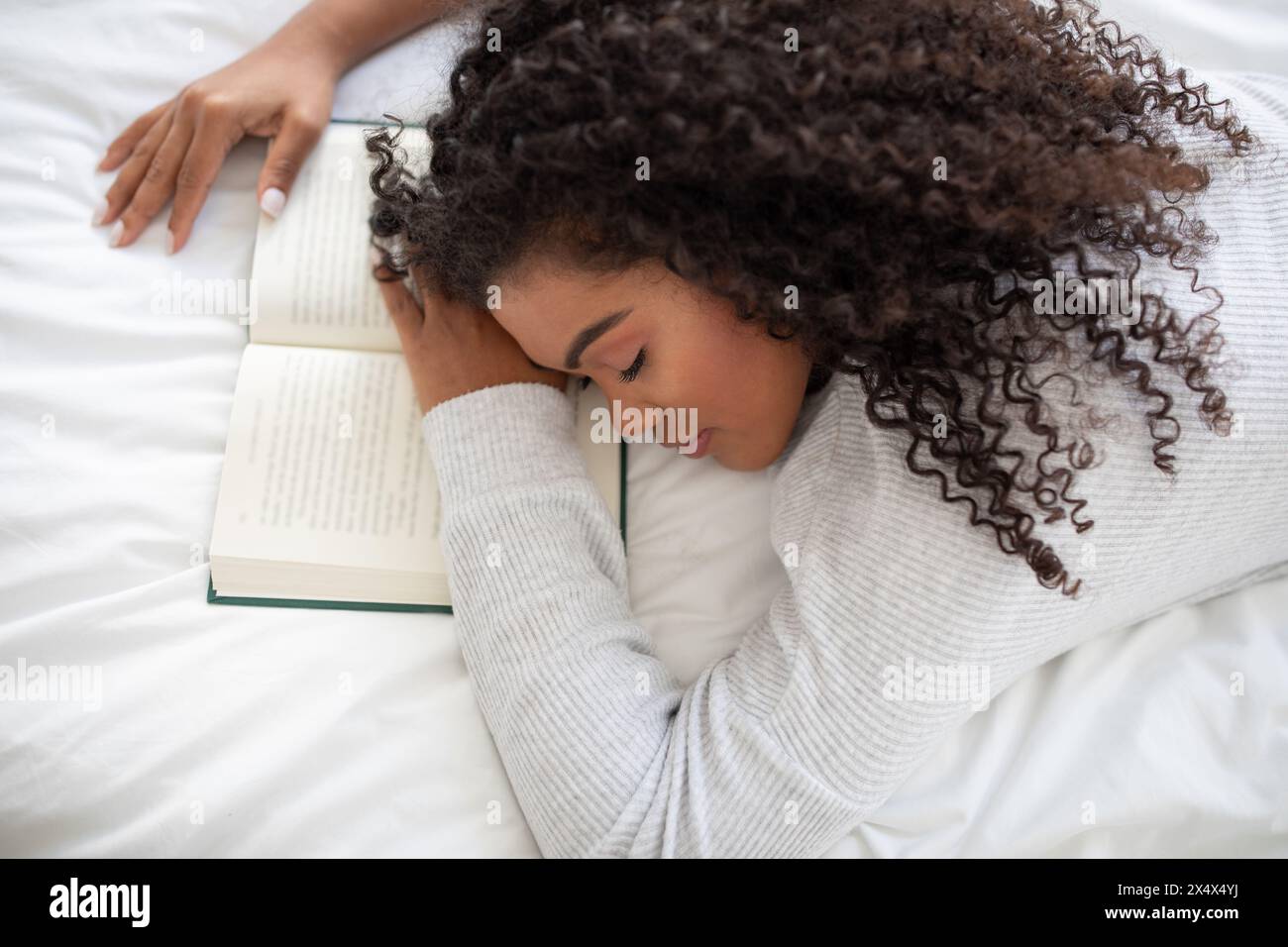 Young Woman Resting on Bed After Reading a Book Stock Photo - Alamy