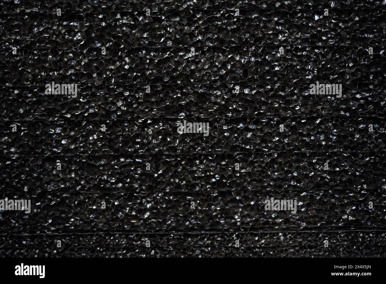 Black porous porous foam background. Background texture of black foam ...