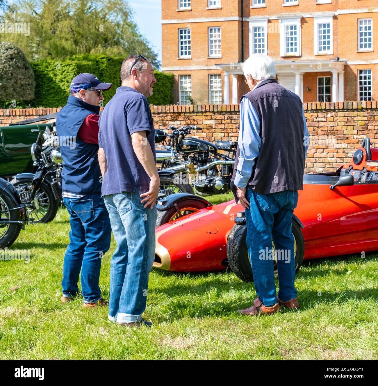 Three men looking around a classic 2 seater sports car Stock Photo - Alamy
