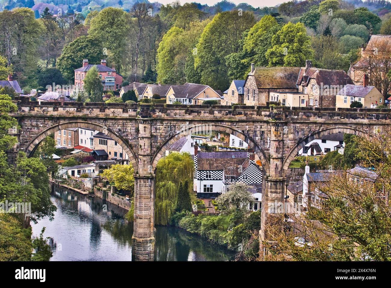 A picturesque view of a stone bridge arching over a river in a quaint ...