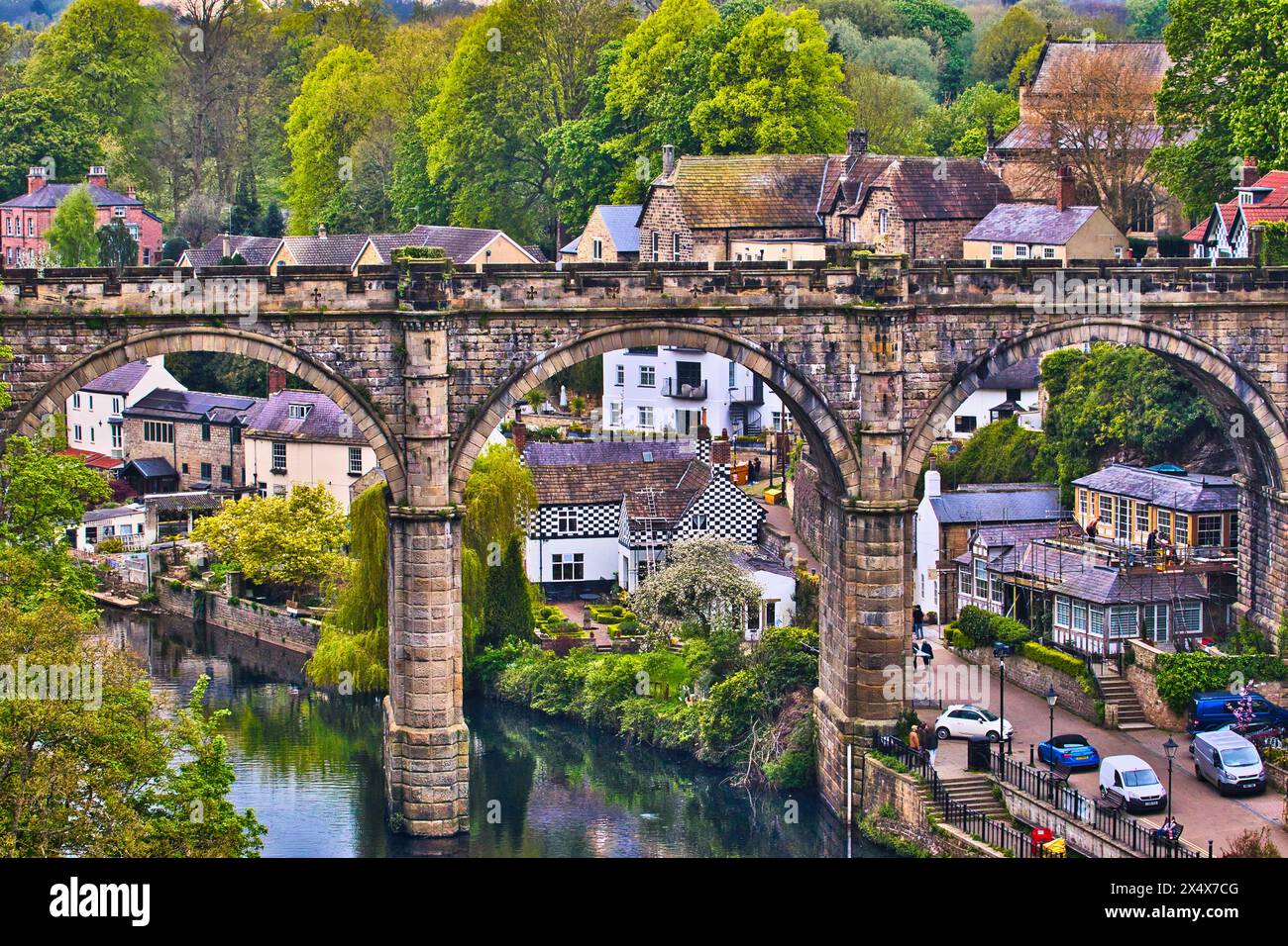 A picturesque view of a stone bridge arching over a river in a quaint ...