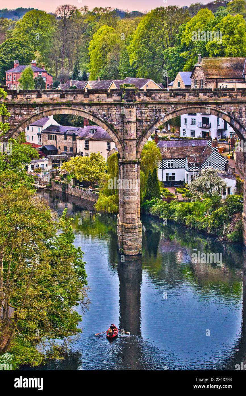 A picturesque view of an old stone bridge arching over a river with a ...