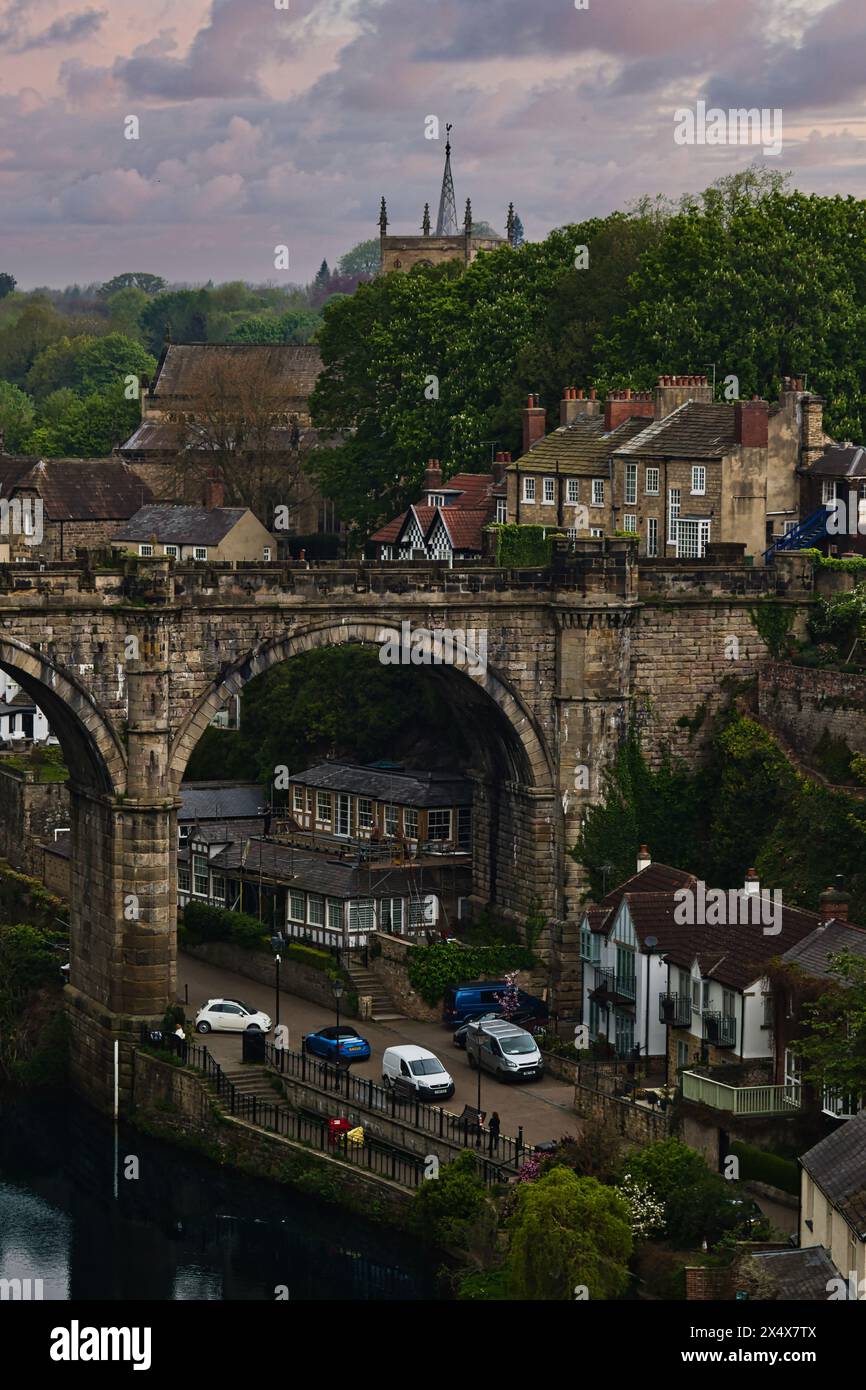 A picturesque view of an old stone bridge arching over a river with ...