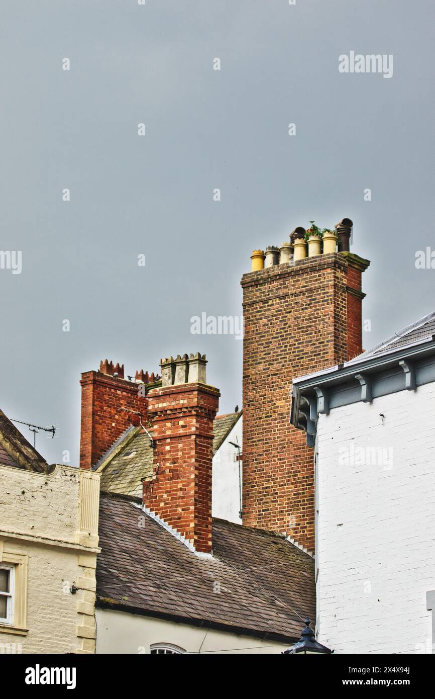 Ornate brick chimneys on historic buildings against a cloudy sky ...