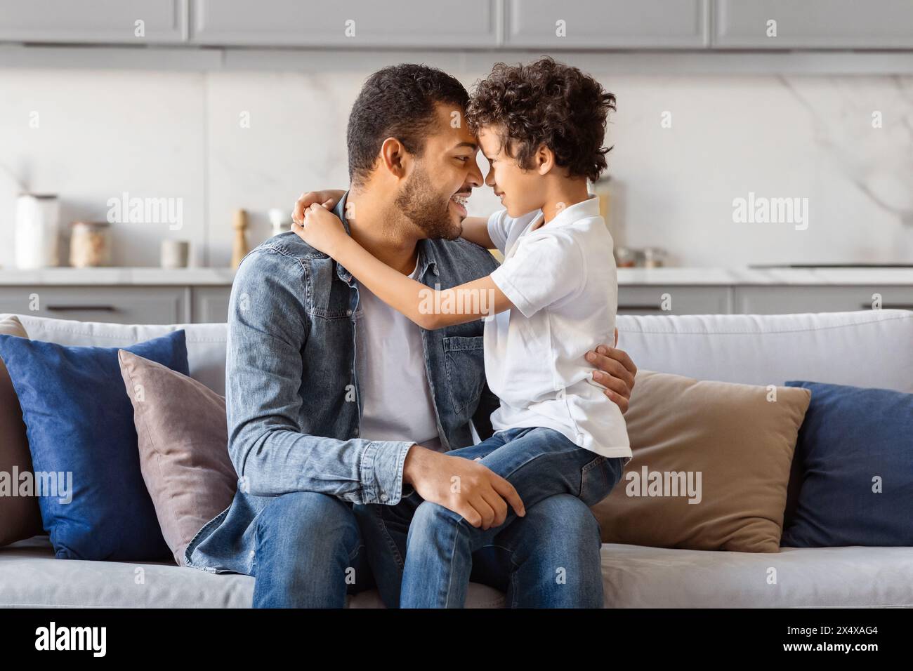 Man Sitting on Top of Couch Holding Little Boy Stock Photo - Alamy