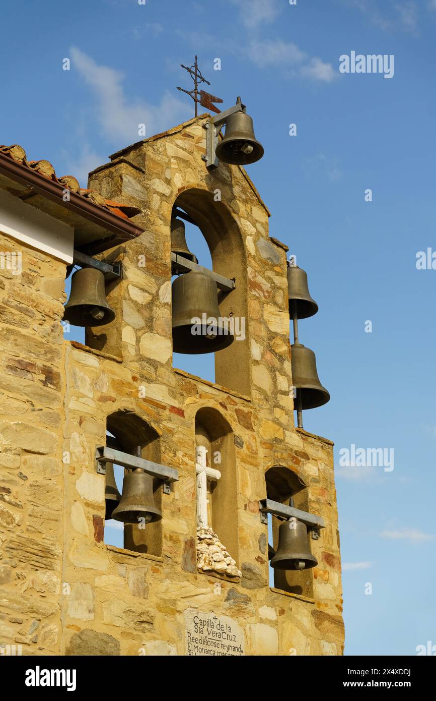 A tall tower featuring bells and a cross on its peak Stock Photo - Alamy