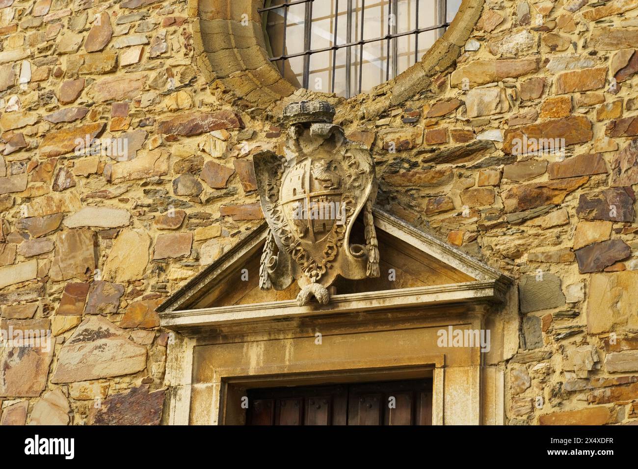 Stylized stone crest with intricate details adorns the exterior wall ...