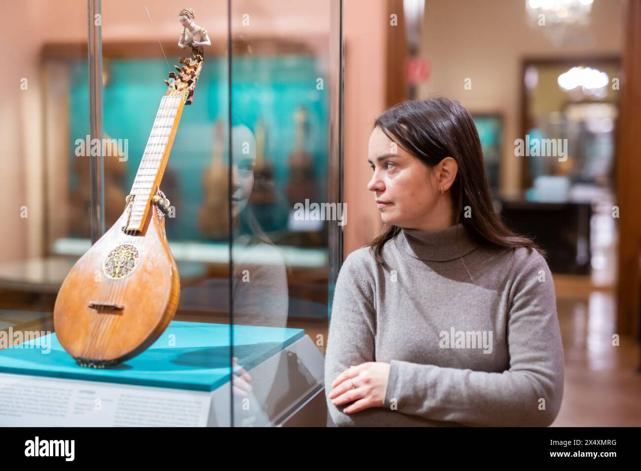 Female museum visitor examining ancient musical instruments Stock Photo ...