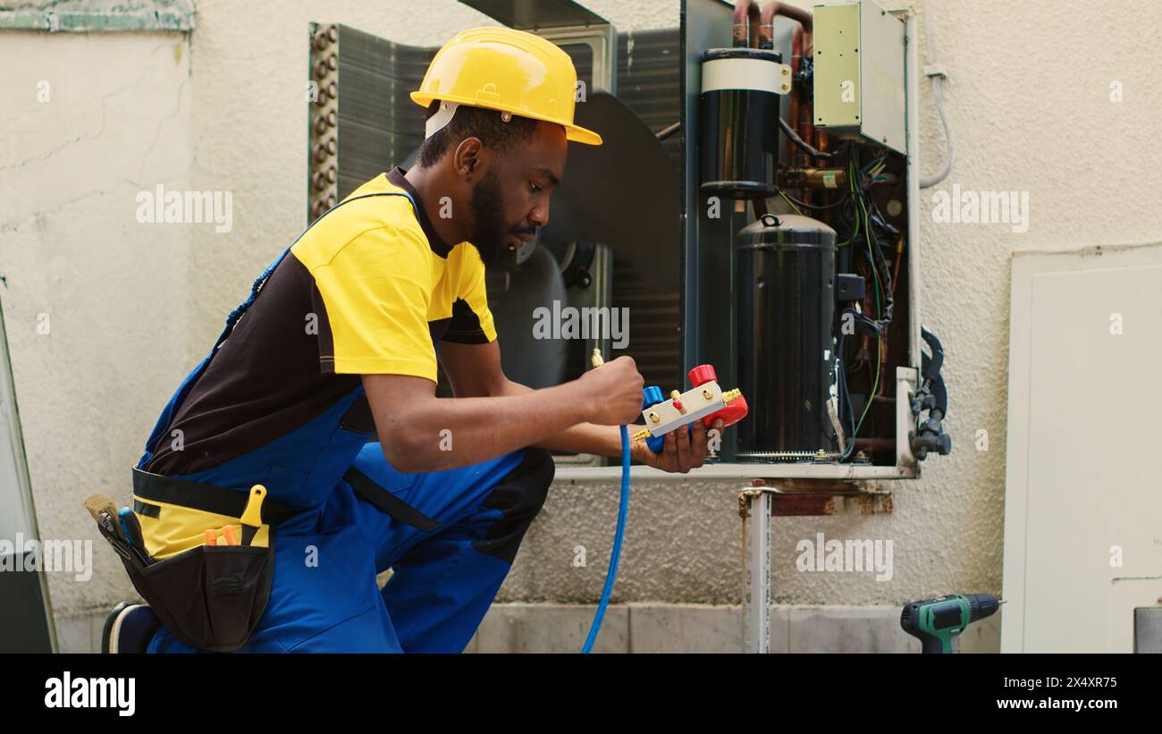 Skilled wireman doing routine air conditioner maintenance, assembling ...
