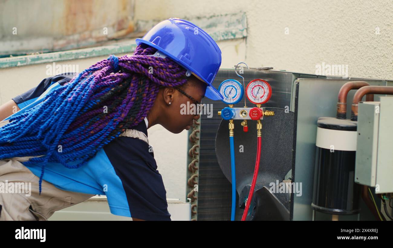 Qualified electrician starting work on busted air conditioner, using ...