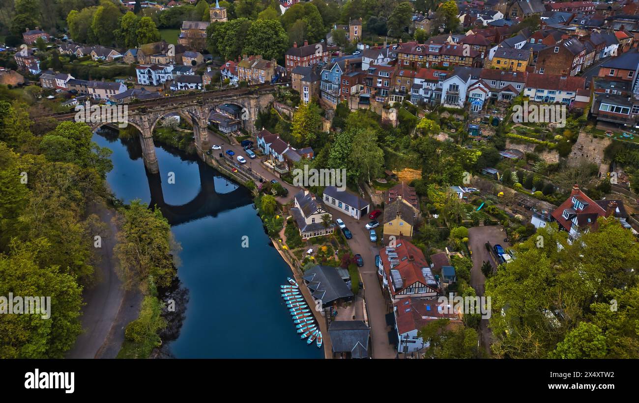 Aerial view of a picturesque town with a river, bridge, and clustered ...