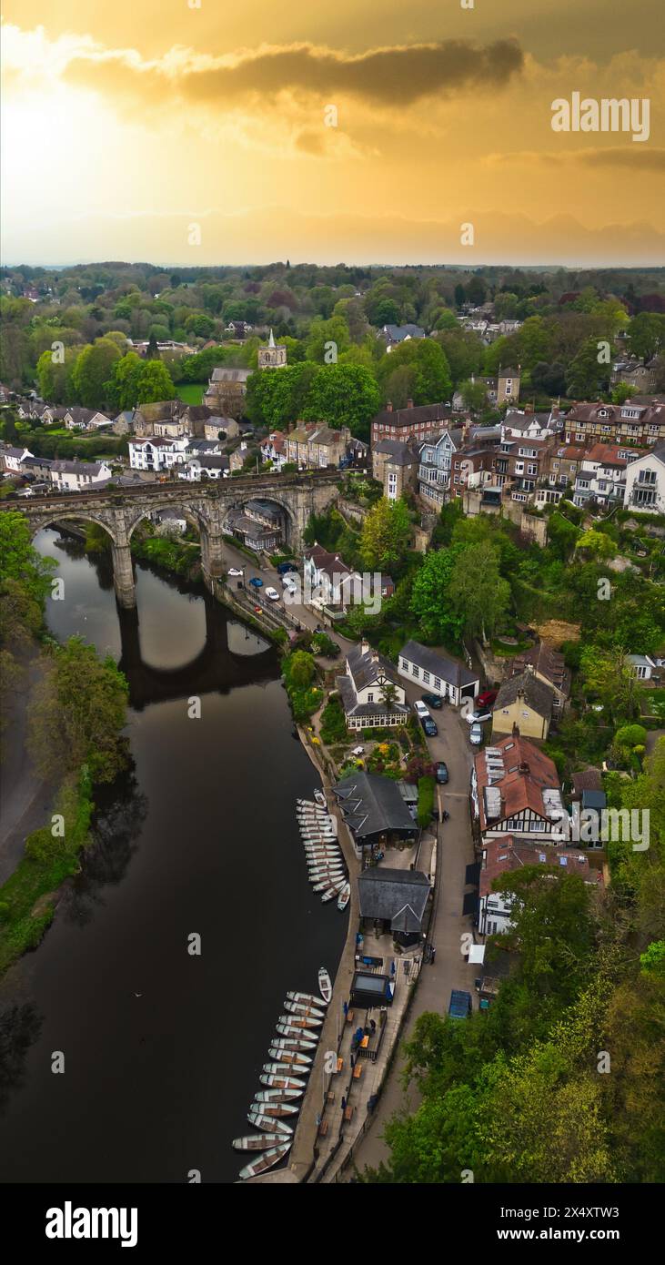 Aerial view of a quaint town with a river curving through, surrounded ...