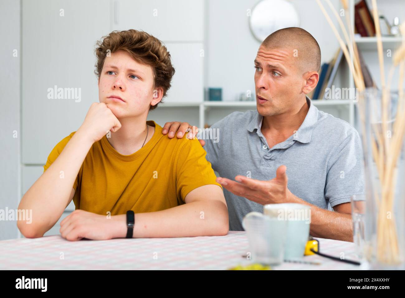 Teenager feeling upset and his father comforting him Stock Photo - Alamy