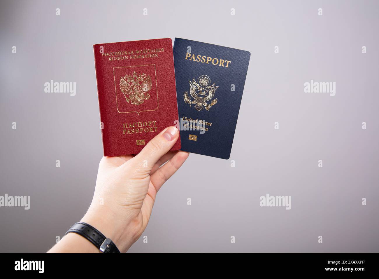 A female hand holding an American passport and a Russian passport Stock ...