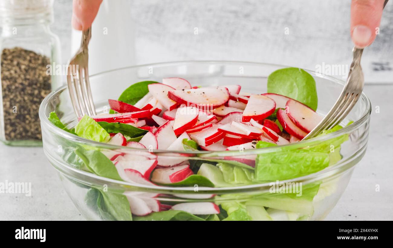 Spring salad in a glass bowl close-up on the kitchen table. Fresh ...