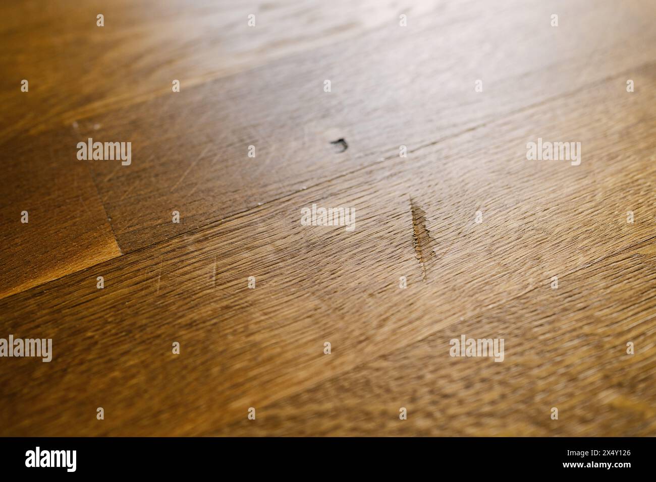 Close-up of a parquet floor with visible scratch by use with defect ...