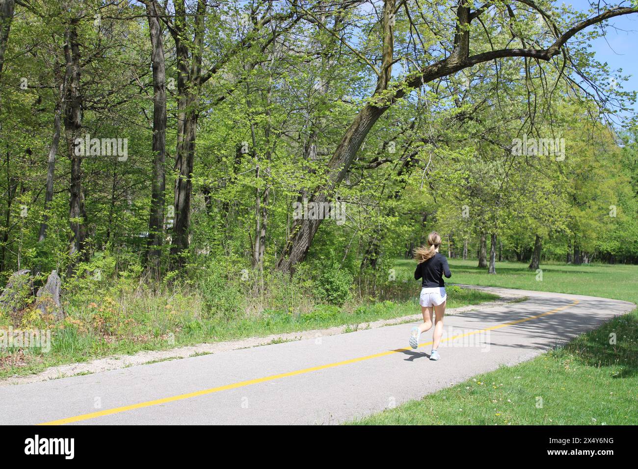 Young woman with a blonde pony tail running on the North Branch Trail ...