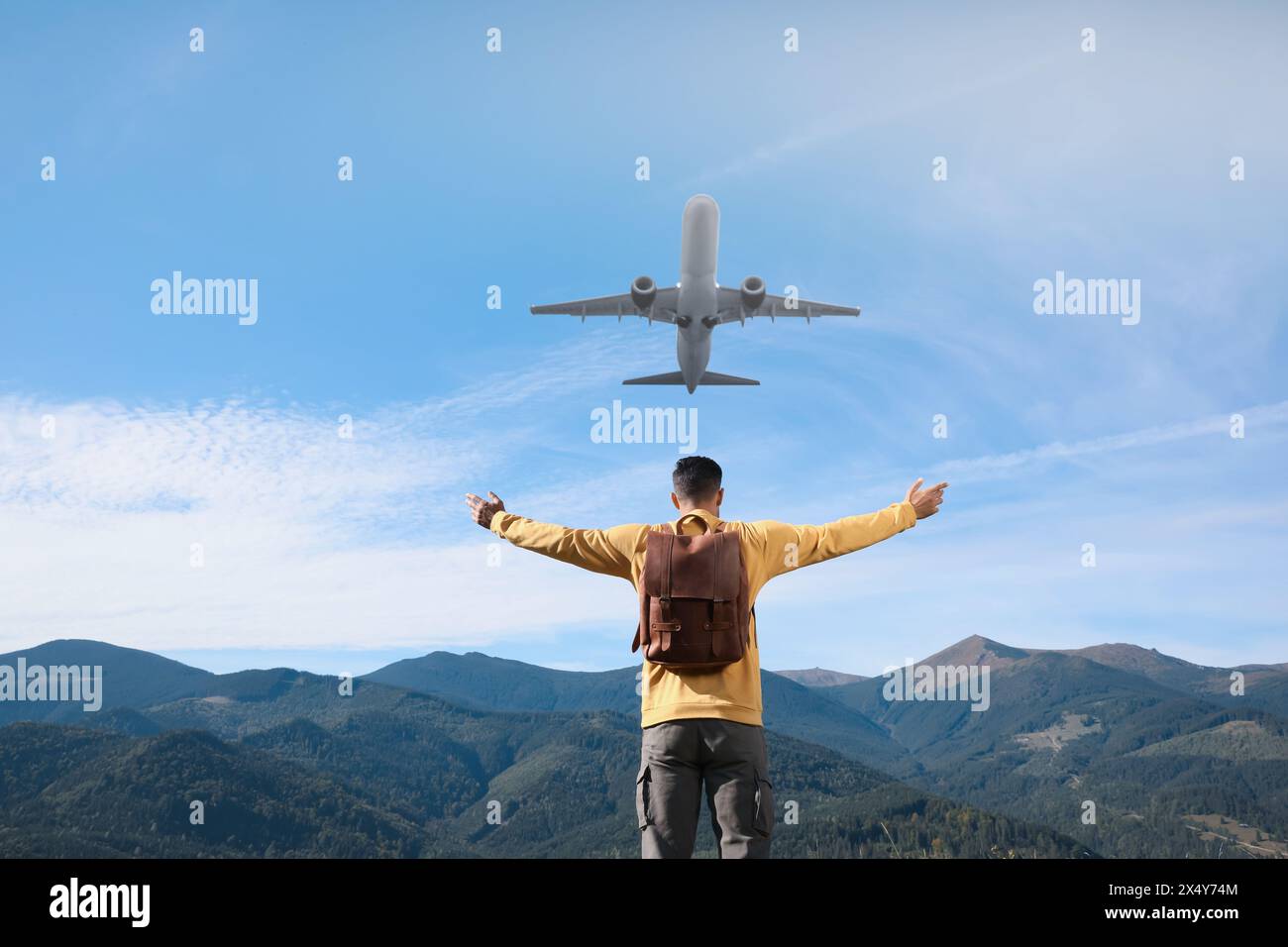 Man looking at airplane flying in sky over mountains, back view Stock ...