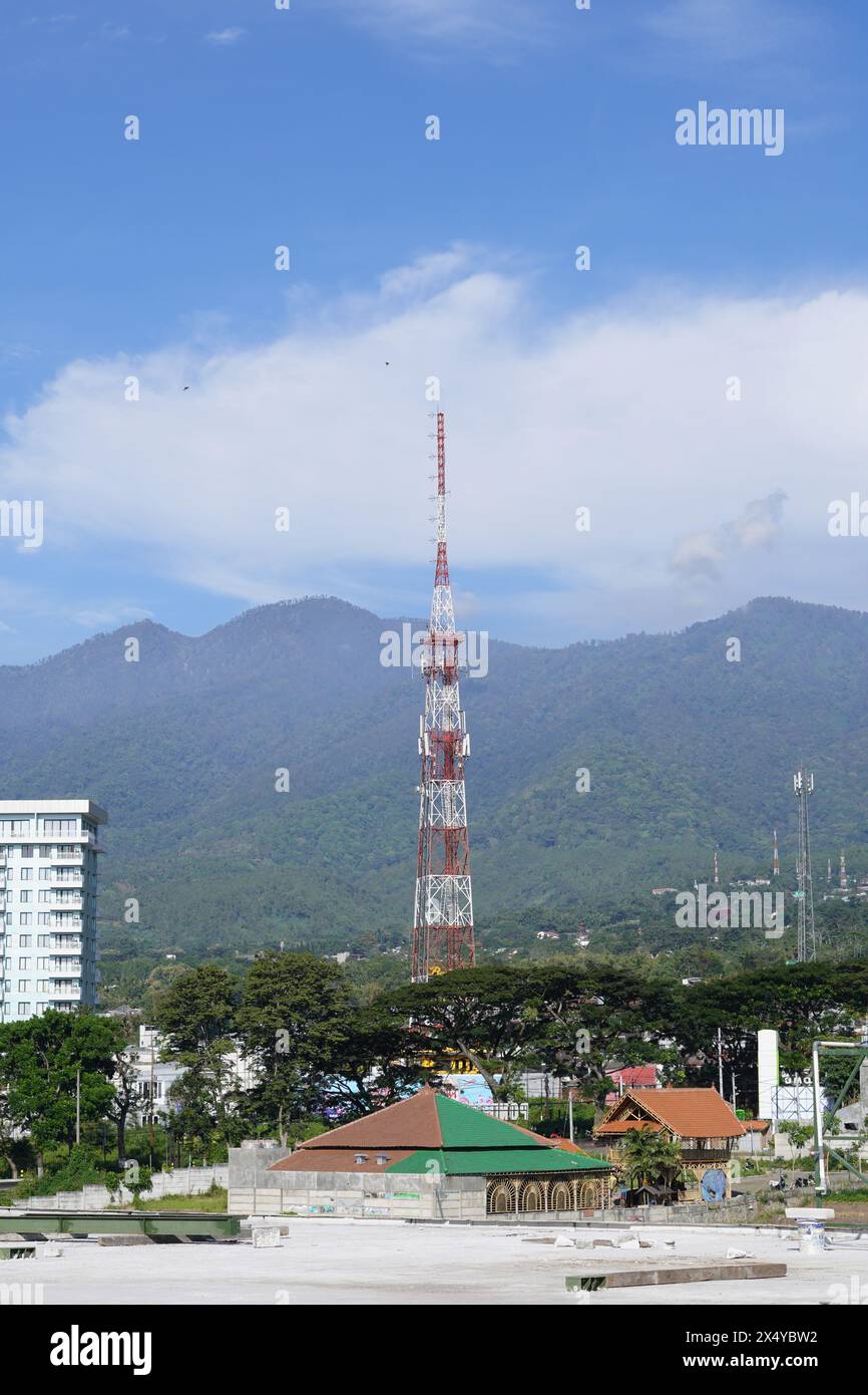 View of green hills with red signal booster towers and clear sky during ...