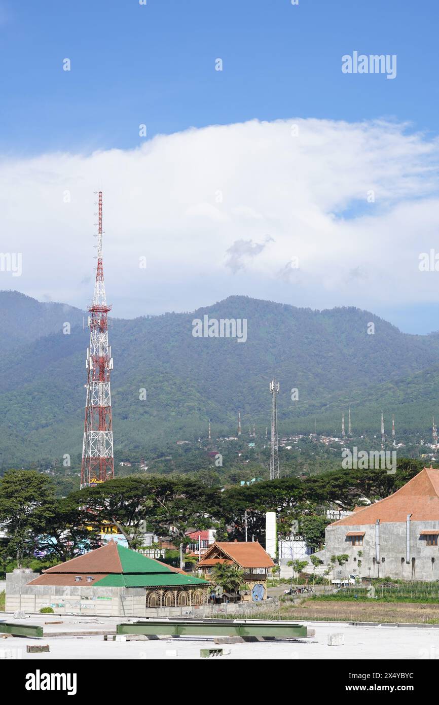View of green hills with red signal booster towers and clear sky during ...