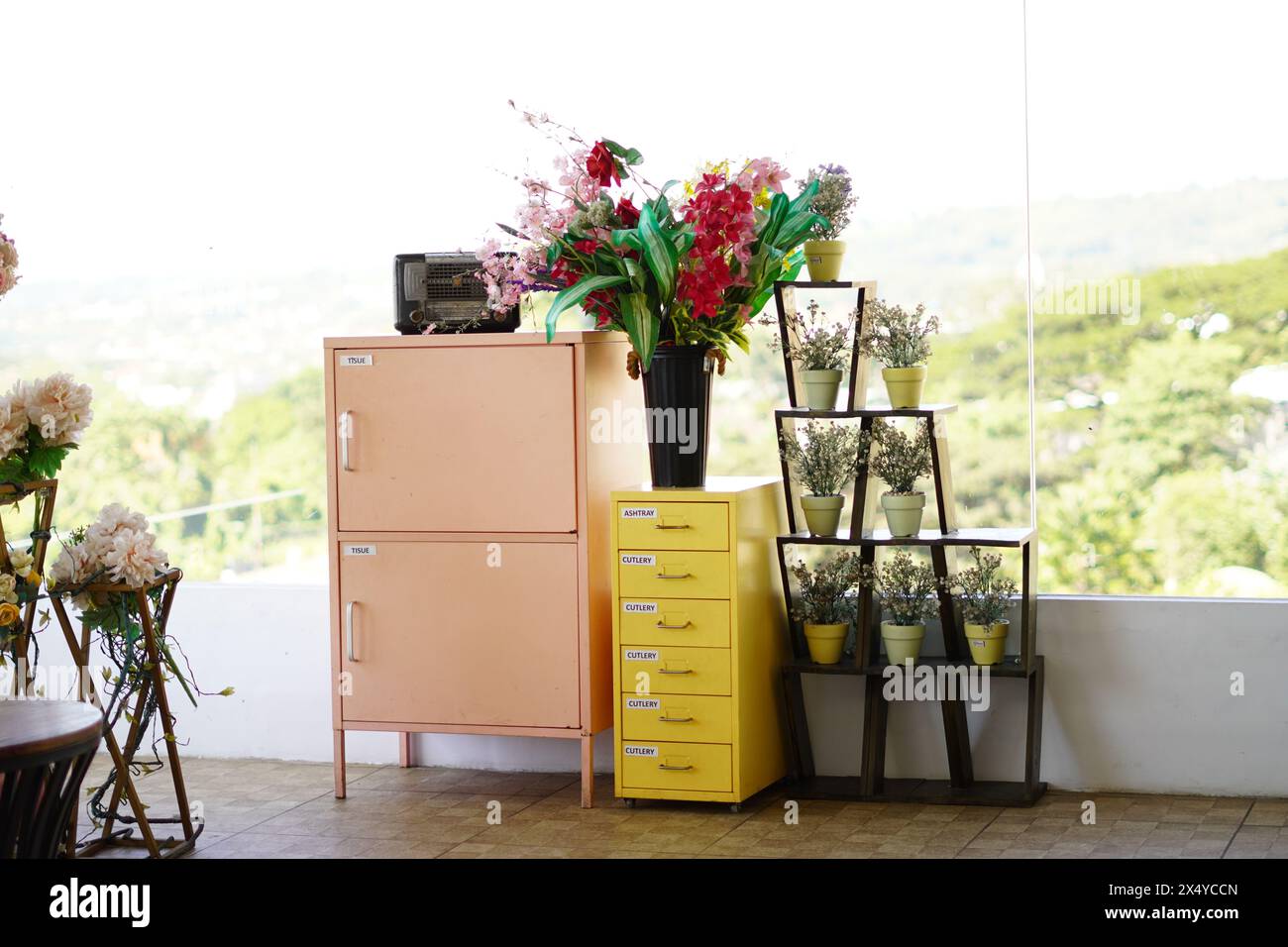 A small, colorful cupboard that decorates a room with fake flowers ...