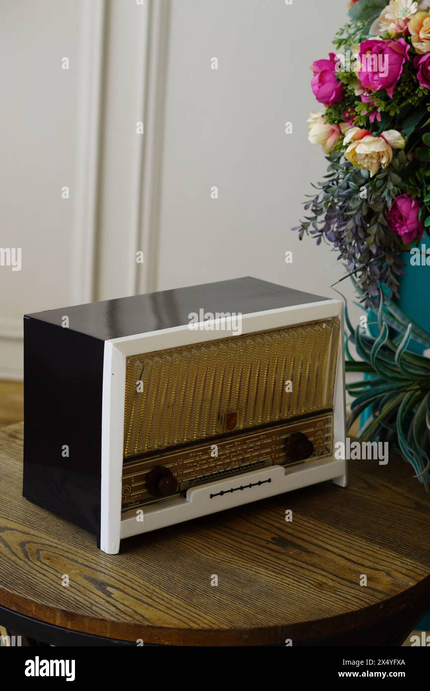 An old vintage style radio placed on a wooden table with a white ...