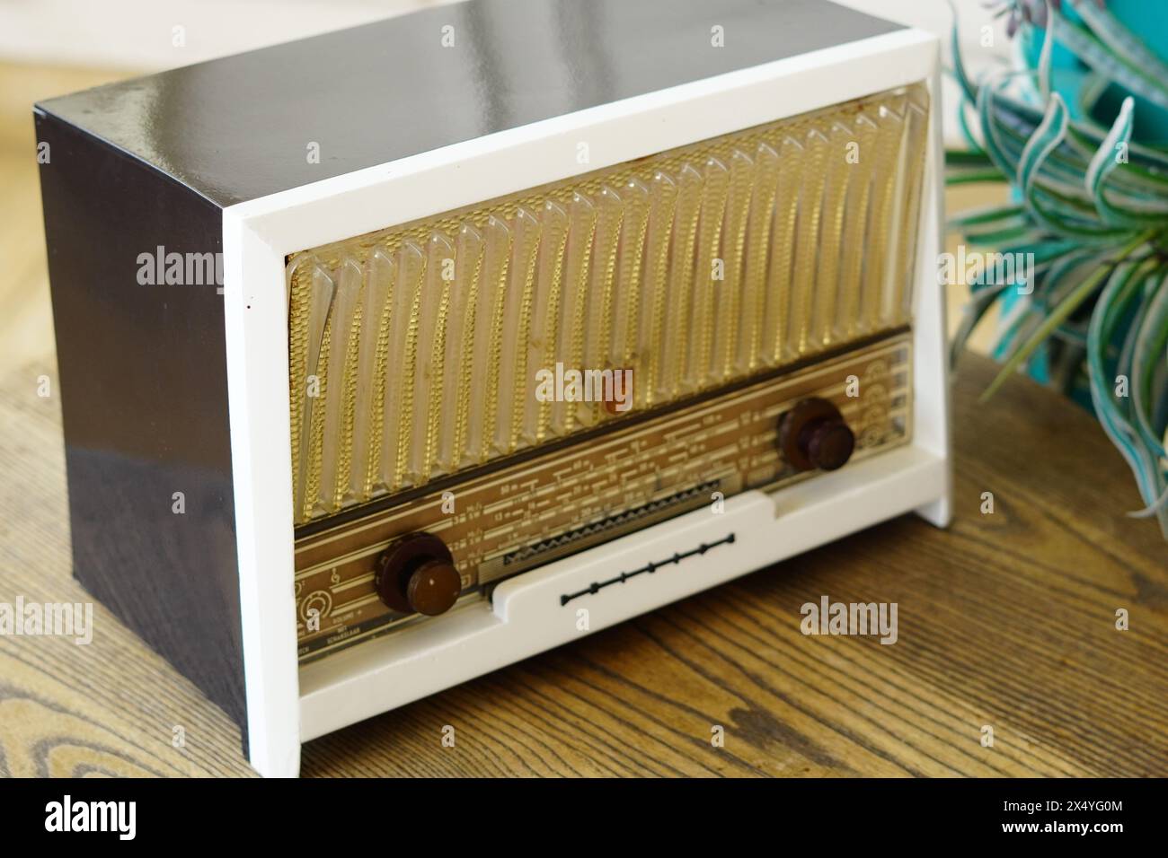 An old vintage style radio placed on a wooden table with a white ...
